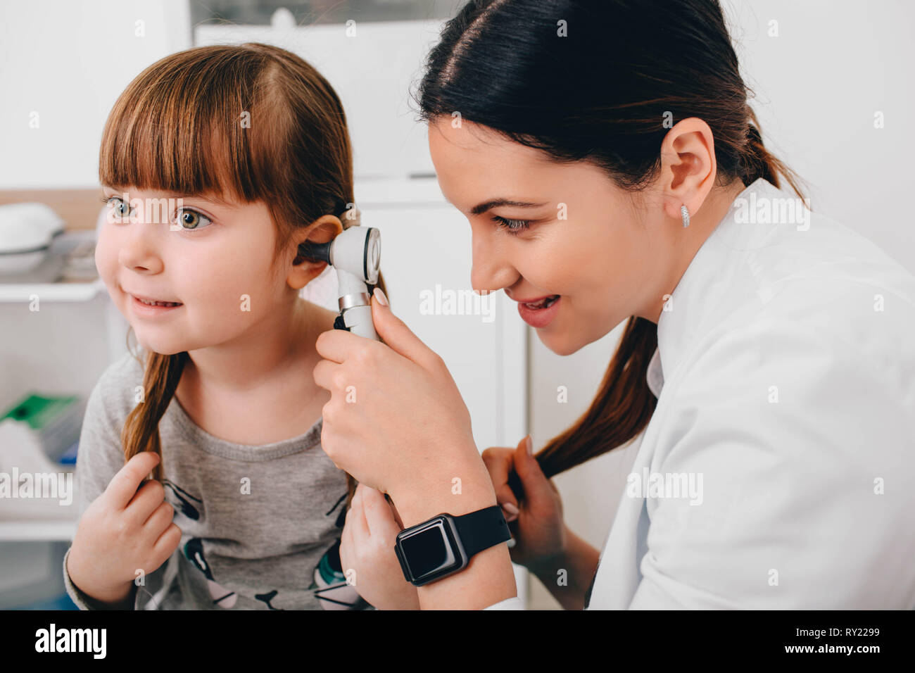 Smiling little girl having ear exam with otoscope Stock Photo - Alamy
