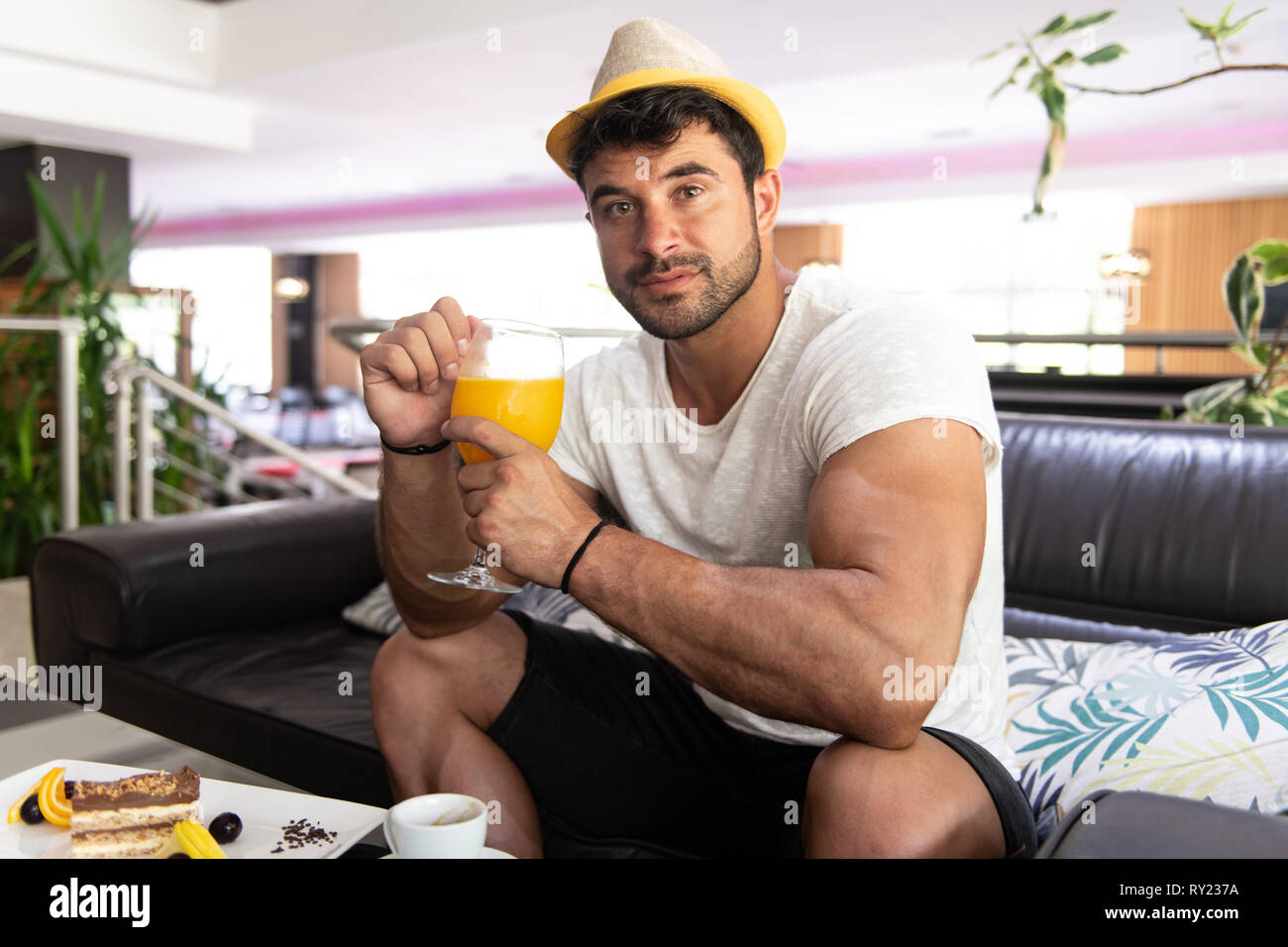 Happy Young Man Sitting Relaxed on Sofa at Luxury Hotel Lobby Bar and ...