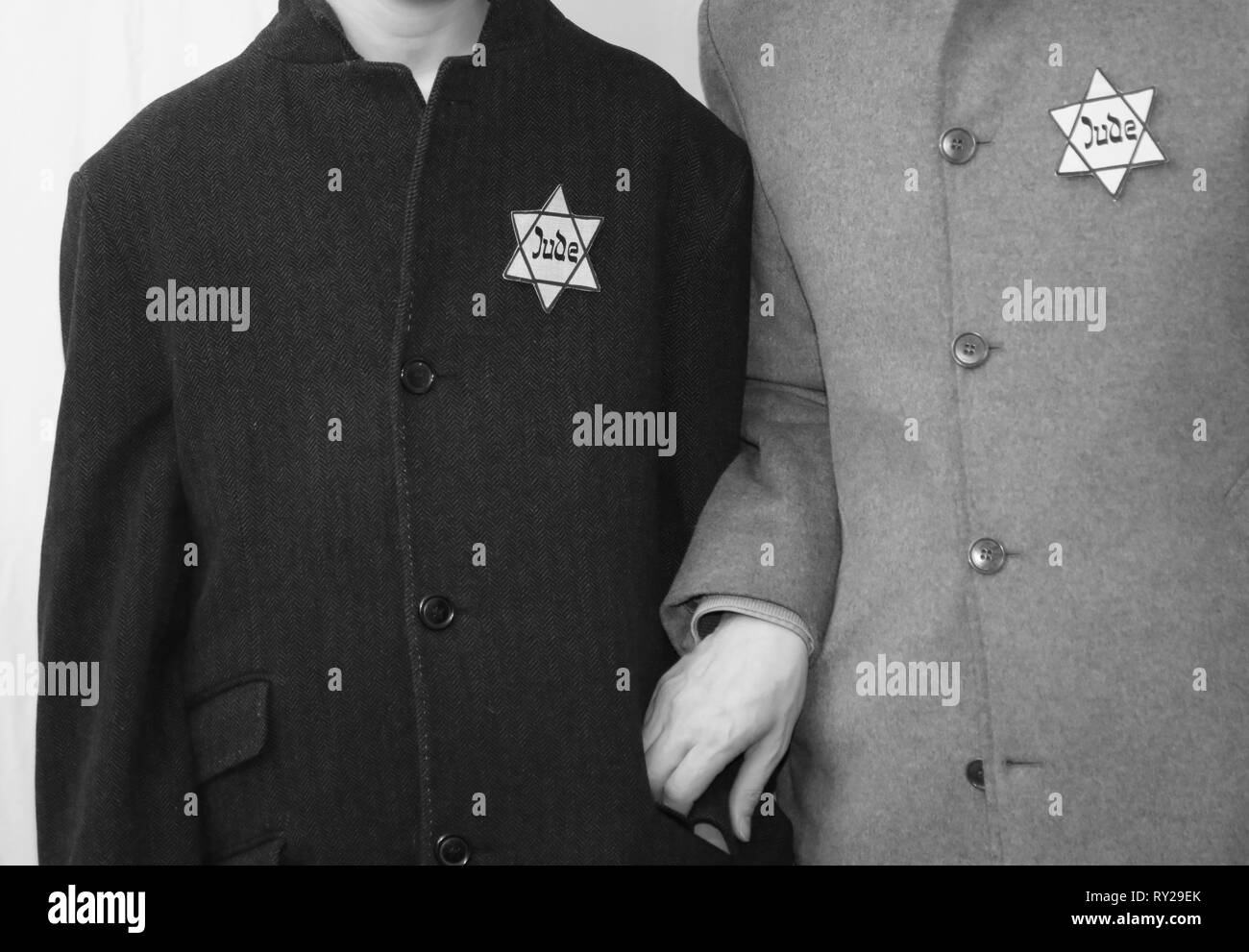 Jewish family with father and young son with old coats and the symbol ...