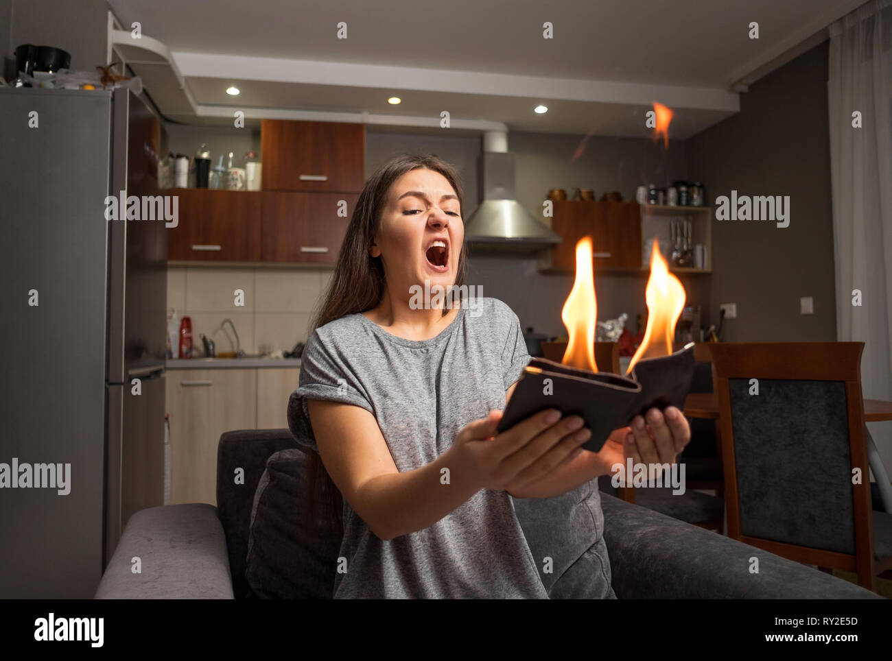 young woman holding a wallet, wallet on fire, surprised girl, magic ...