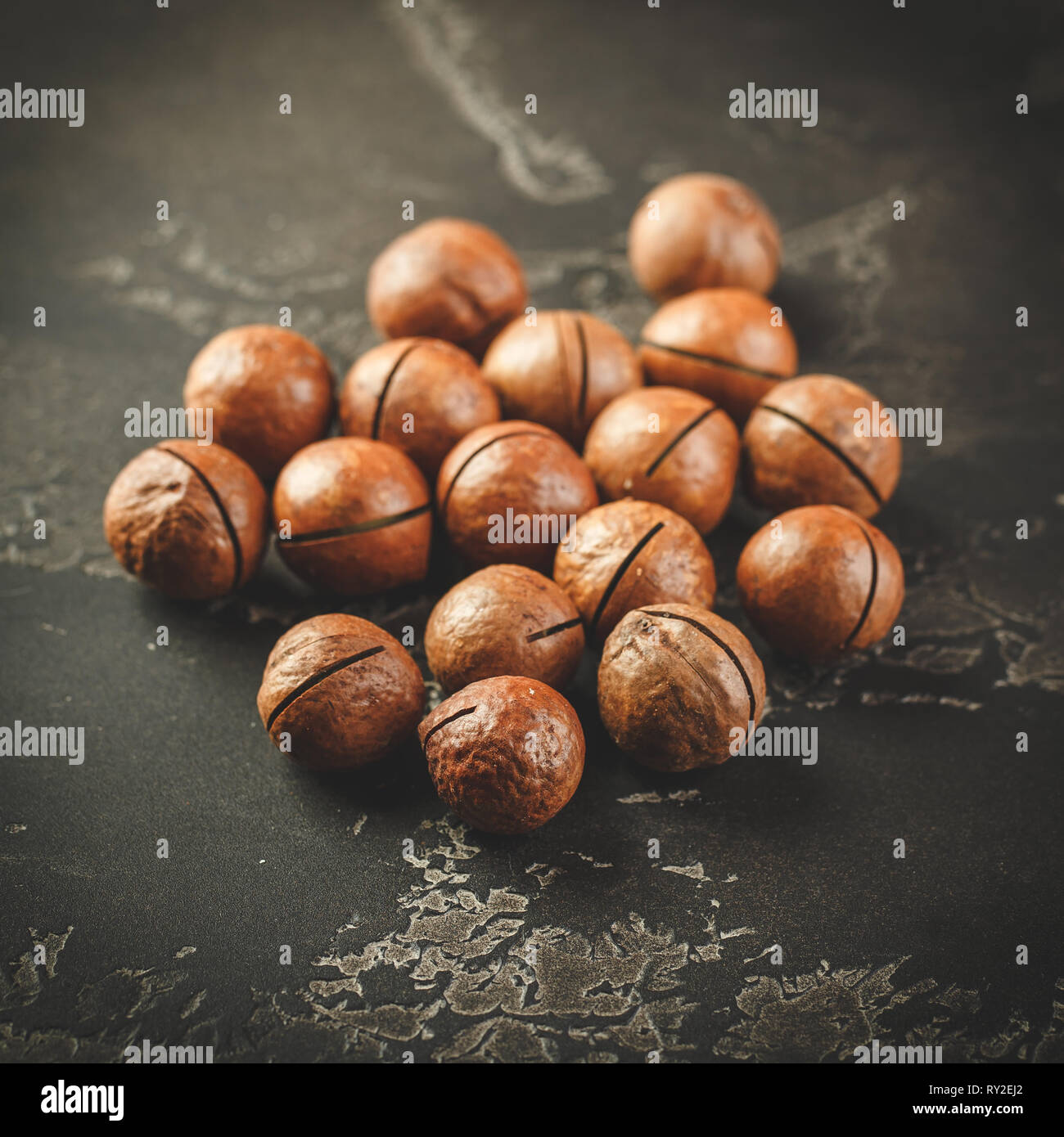 Organic Macadamia nuts in on dark cocrete background close up Stock ...