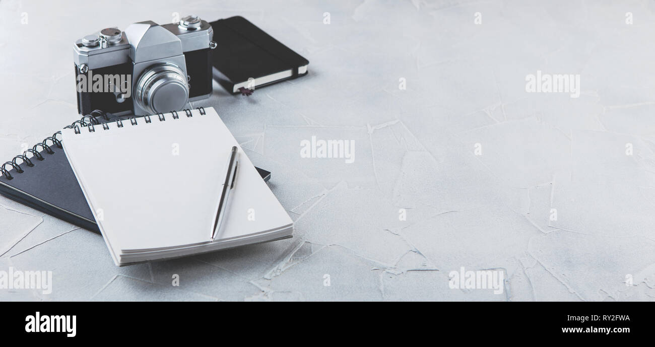 Retro photo film camera with note books, pen on light background Stock ...