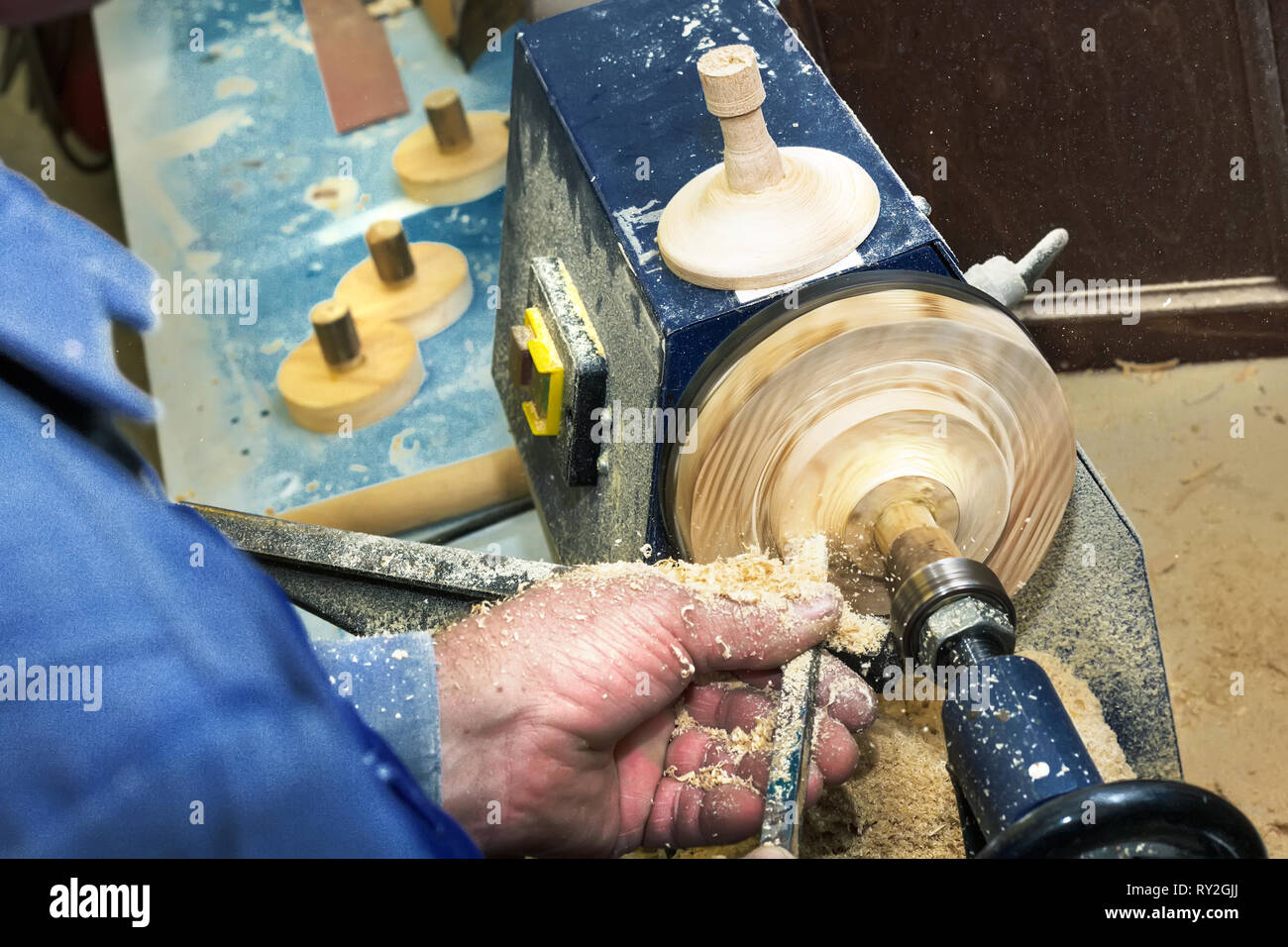 Work carpenter on a lathe on a tree. Close-up of a man's hands with a ...