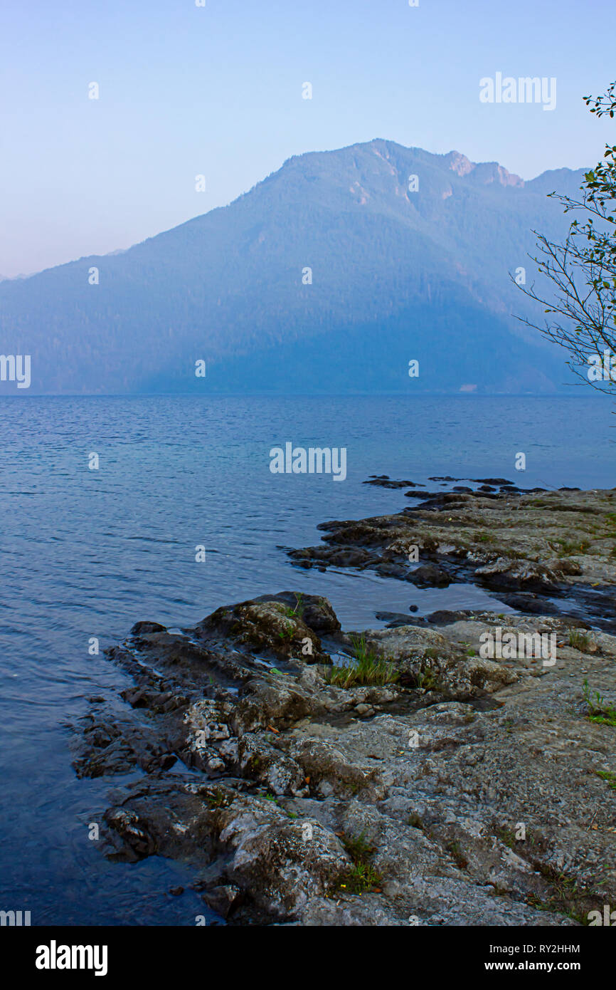lake shore edge with dark rugged rocky stones Stock Photo - Alamy