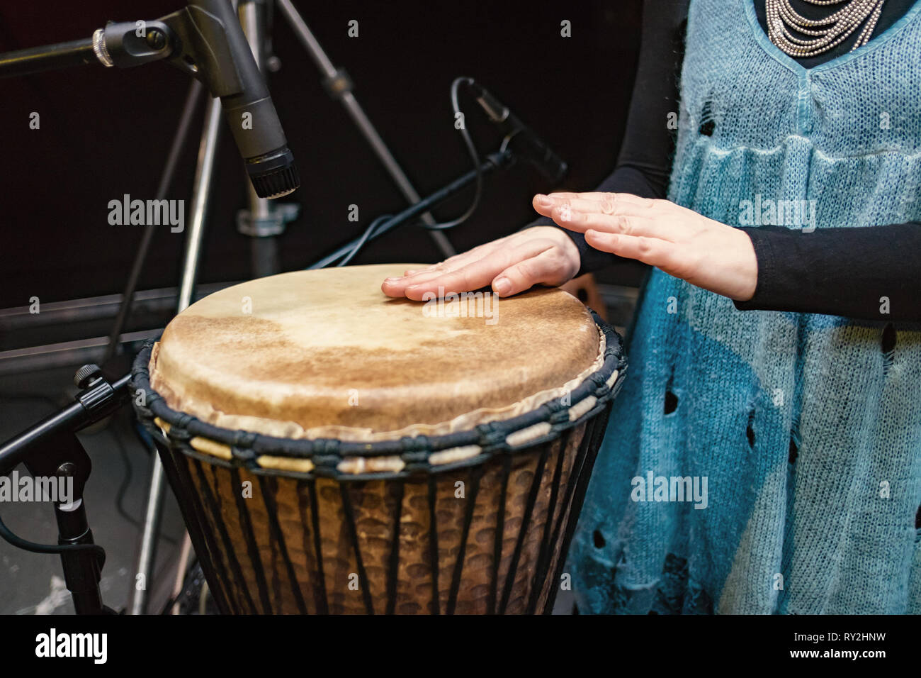 African drum, microphone studio recording, drummer beats the drum with ...