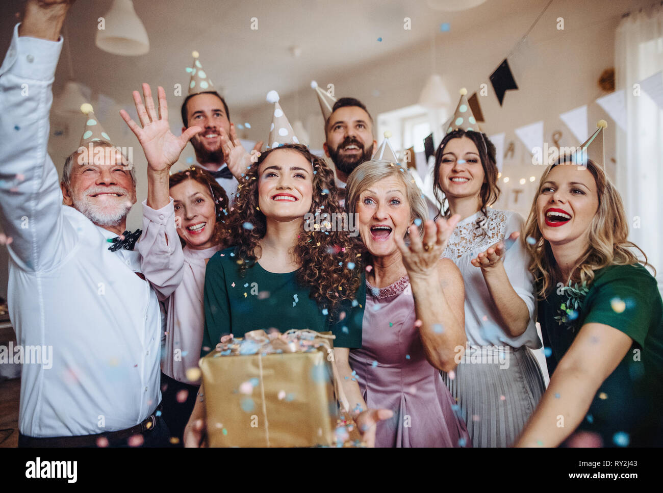 A portrait of multigeneration family with presents standing indoor on a ...