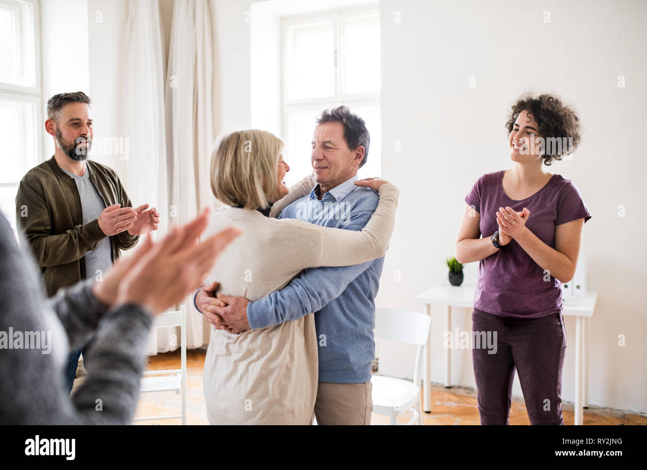Group of men and women during group therapy, showing signs of relief ...