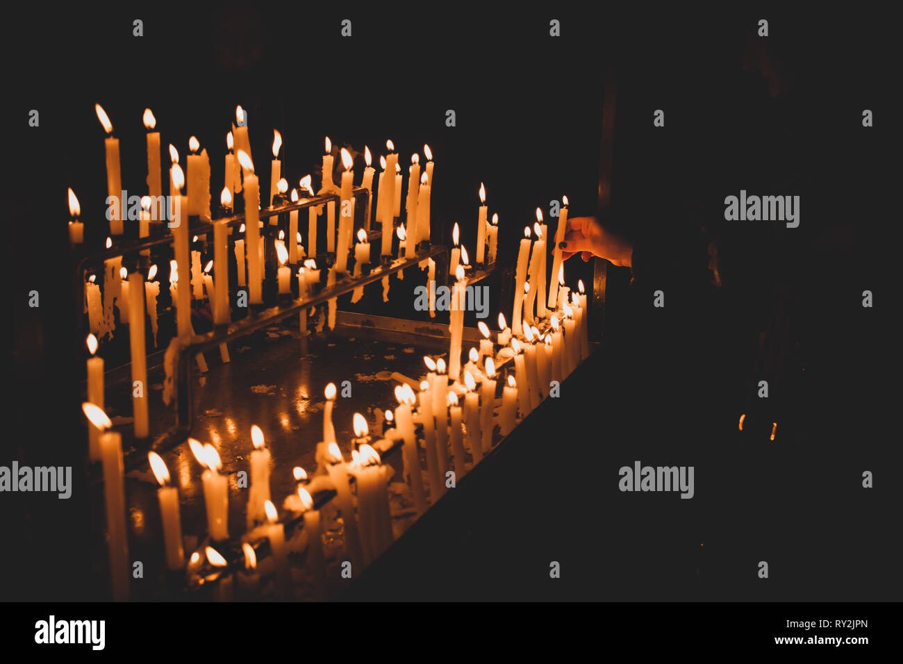 Candle flames in the church. Dark mood with burnt candles Stock Photo ...