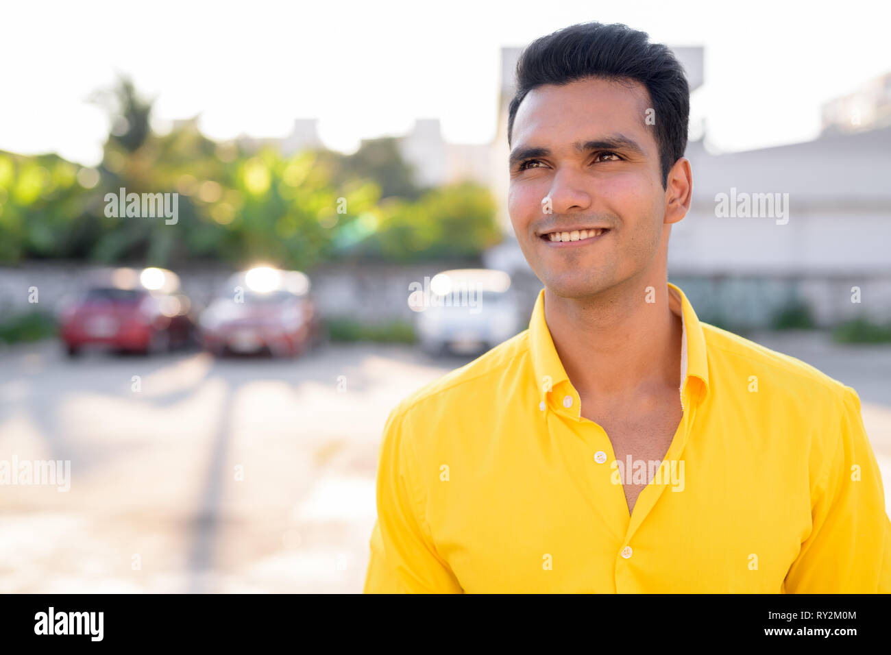 Portrait of young handsome Indian man in the streets outdoors Stock ...