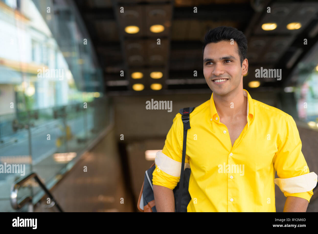 Young happy Indian man thinking at the subway train station Stock Photo ...