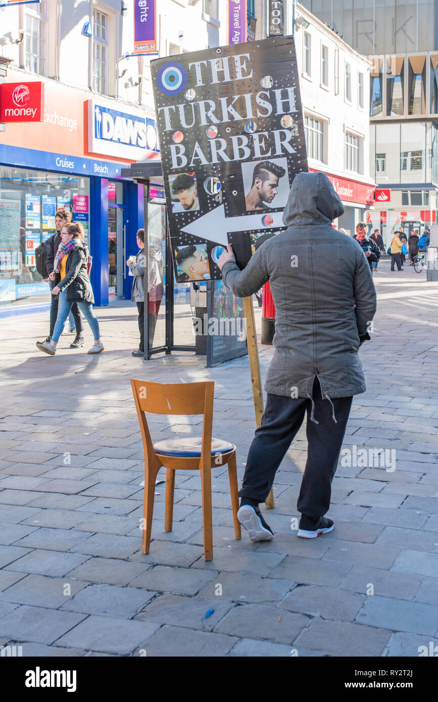 Man with a mobile advert for a barber's shop in Newcastle city centre ...