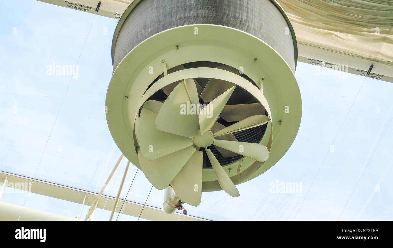 A white propeller fan on the top of the building of the botanial garden ...