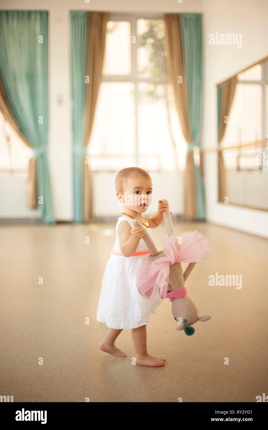 Cute adorable baby girl playing with first doll Stock Photo - Alamy
