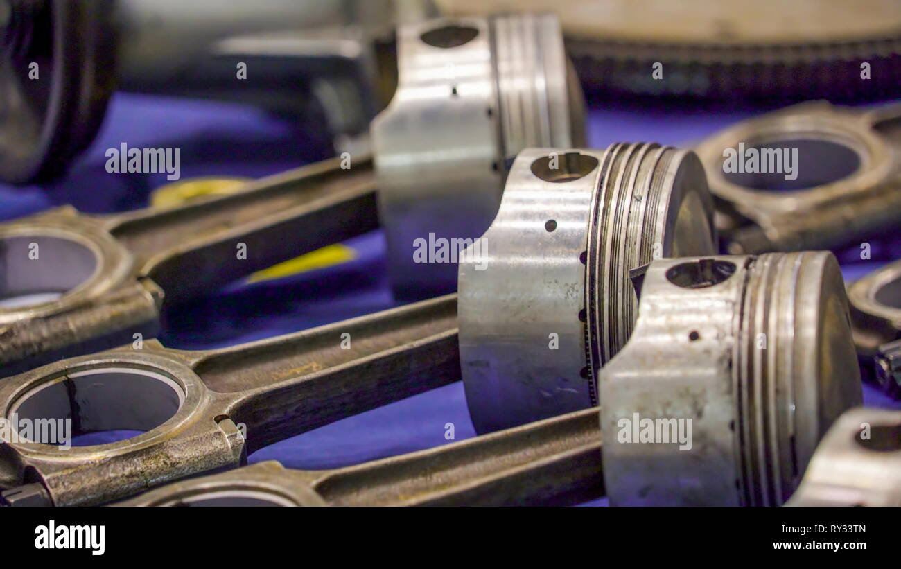 Lots of piston parts of the car in the table being displayed inside the ...