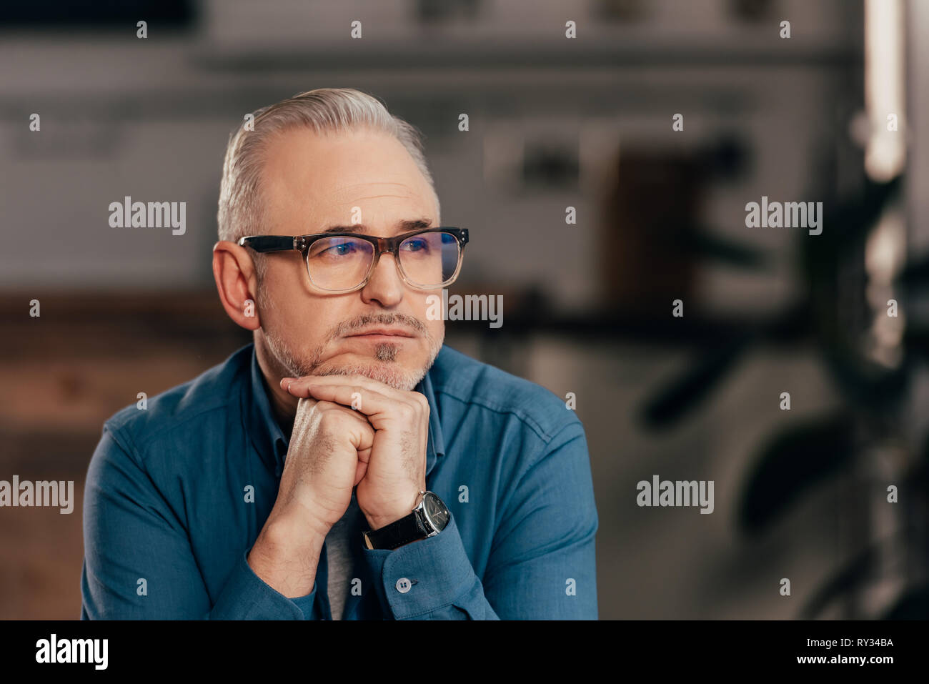 handsome sad man sitting in glasses at home Stock Photo - Alamy