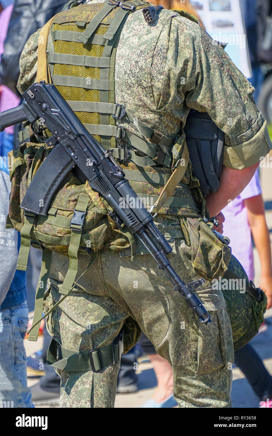 A soldier in camouflage with a gun behind his back. Rear view Stock ...