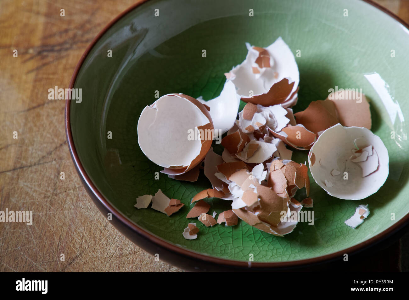 Egg shell on green plate, concept background Stock Photo - Alamy