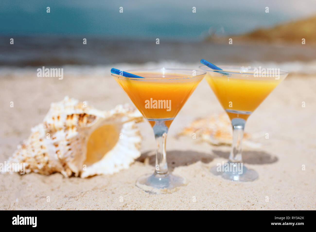 Summer concept: fresh exotic orange cocktails on the beach. Beautiful ...