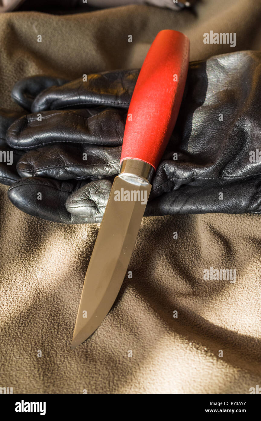 Knife and leather gloves. A sharp hunting knife. Vertical frame Stock ...