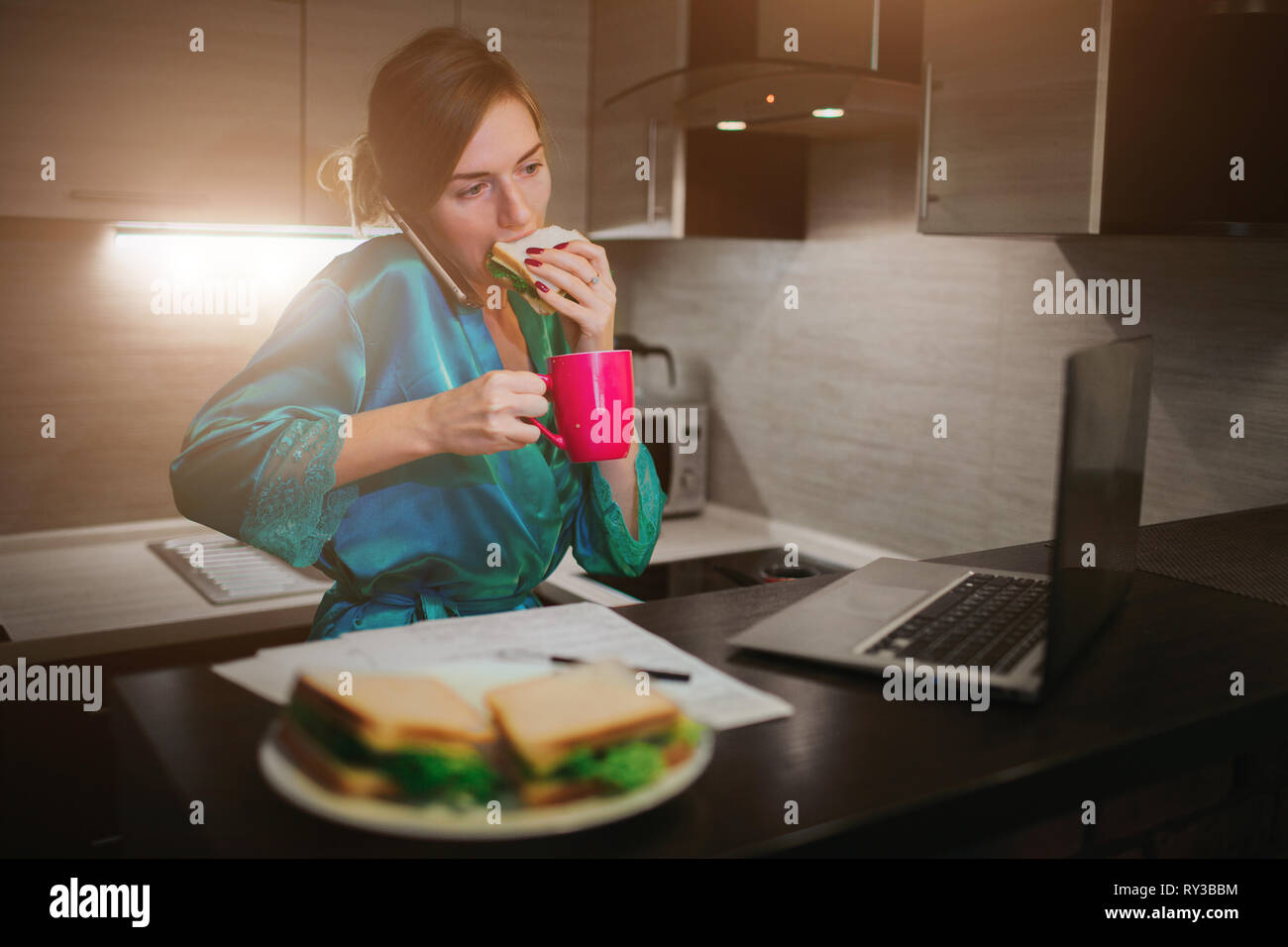 Busy woman eating, drinking coffee, talking on the phone, working on a ...