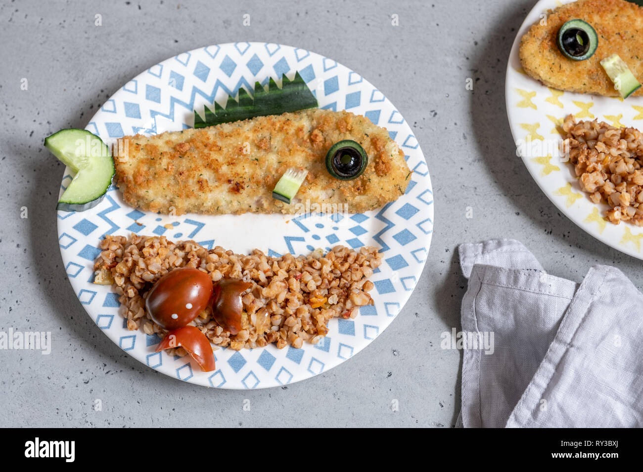 Funny dinner with fish and buckwheat for kids Stock Photo - Alamy