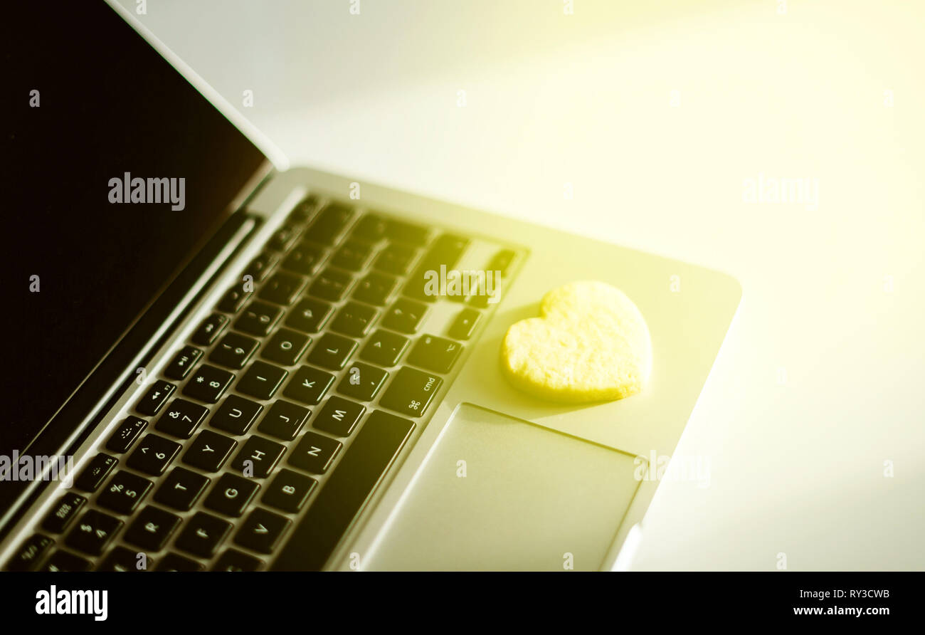 Heart shaped cookie snack on modern aluminium professional laptop ...