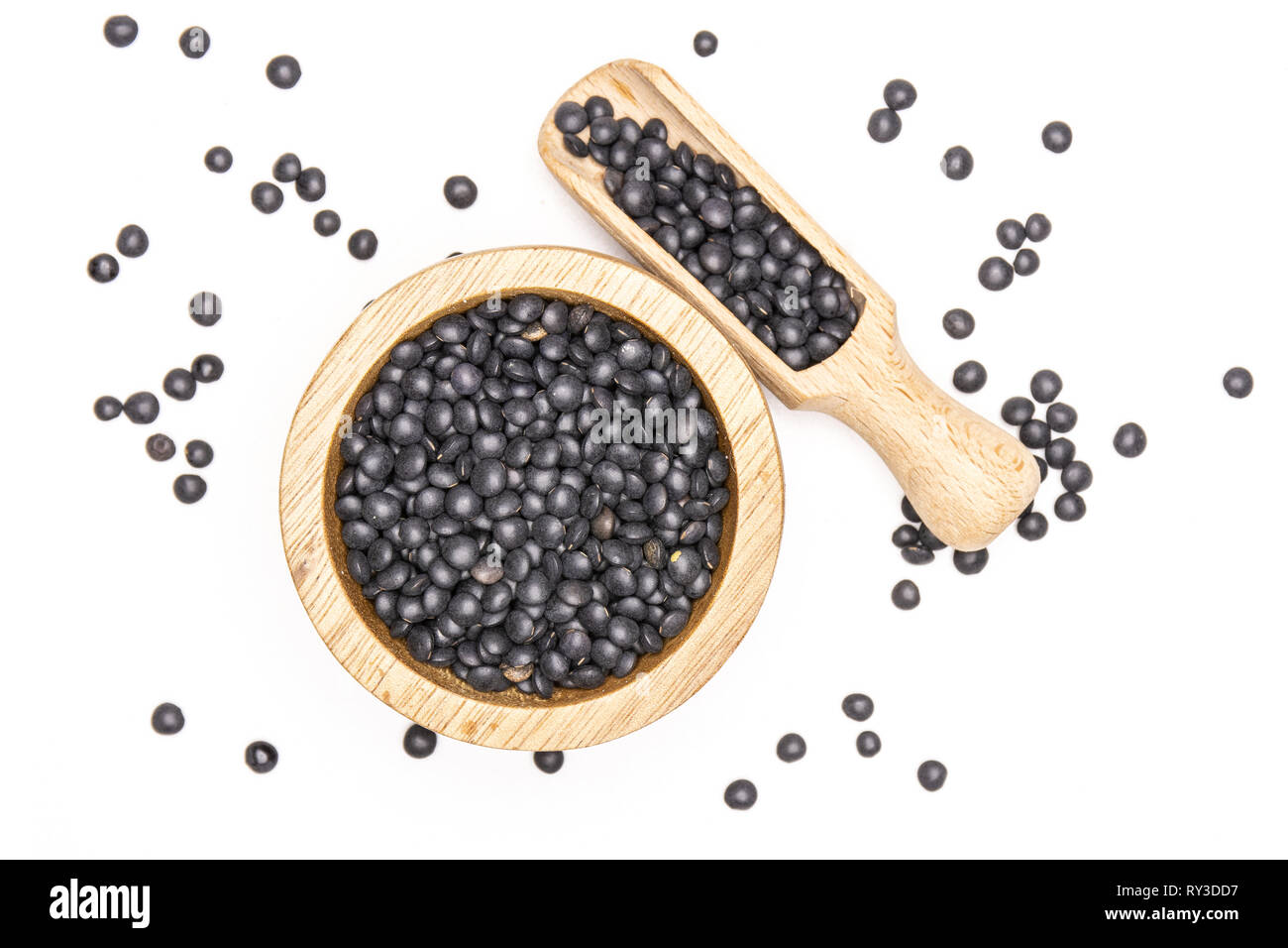Lot of whole raw black lentils beluga variety with wooden bowl flatlay ...