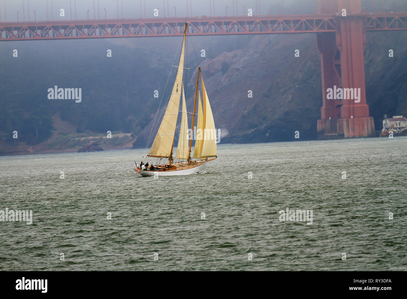 Sailboat with raised sails approaching Golden Gate Bridge crossing San ...