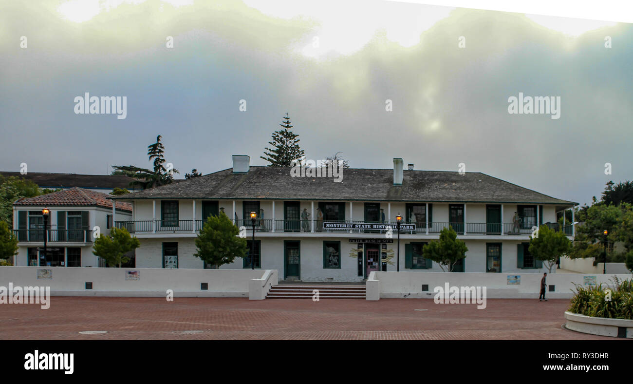 Low wide building beneath cloudy skies with stone walls and staircase ...