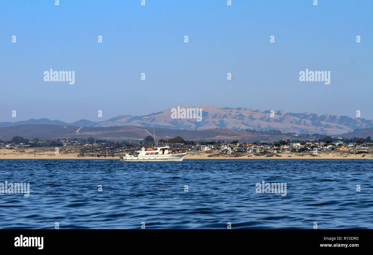 White boat viewed from the sea against the shore landscape with ...
