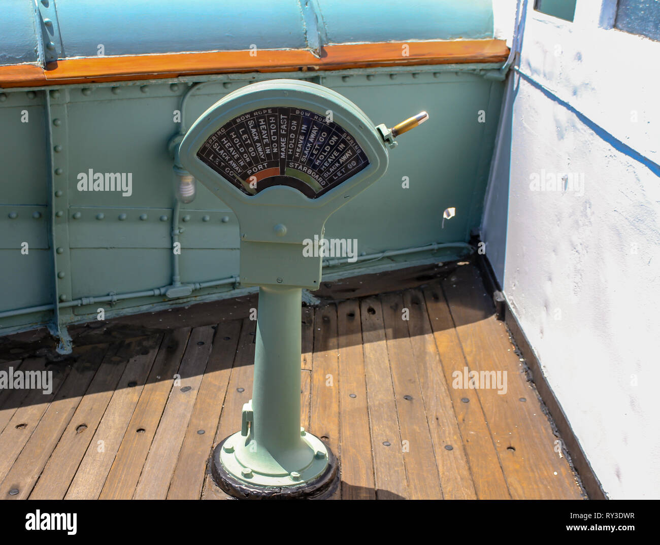 Vintage engine order telegraph on dock of an old vessel, painted cyan ...