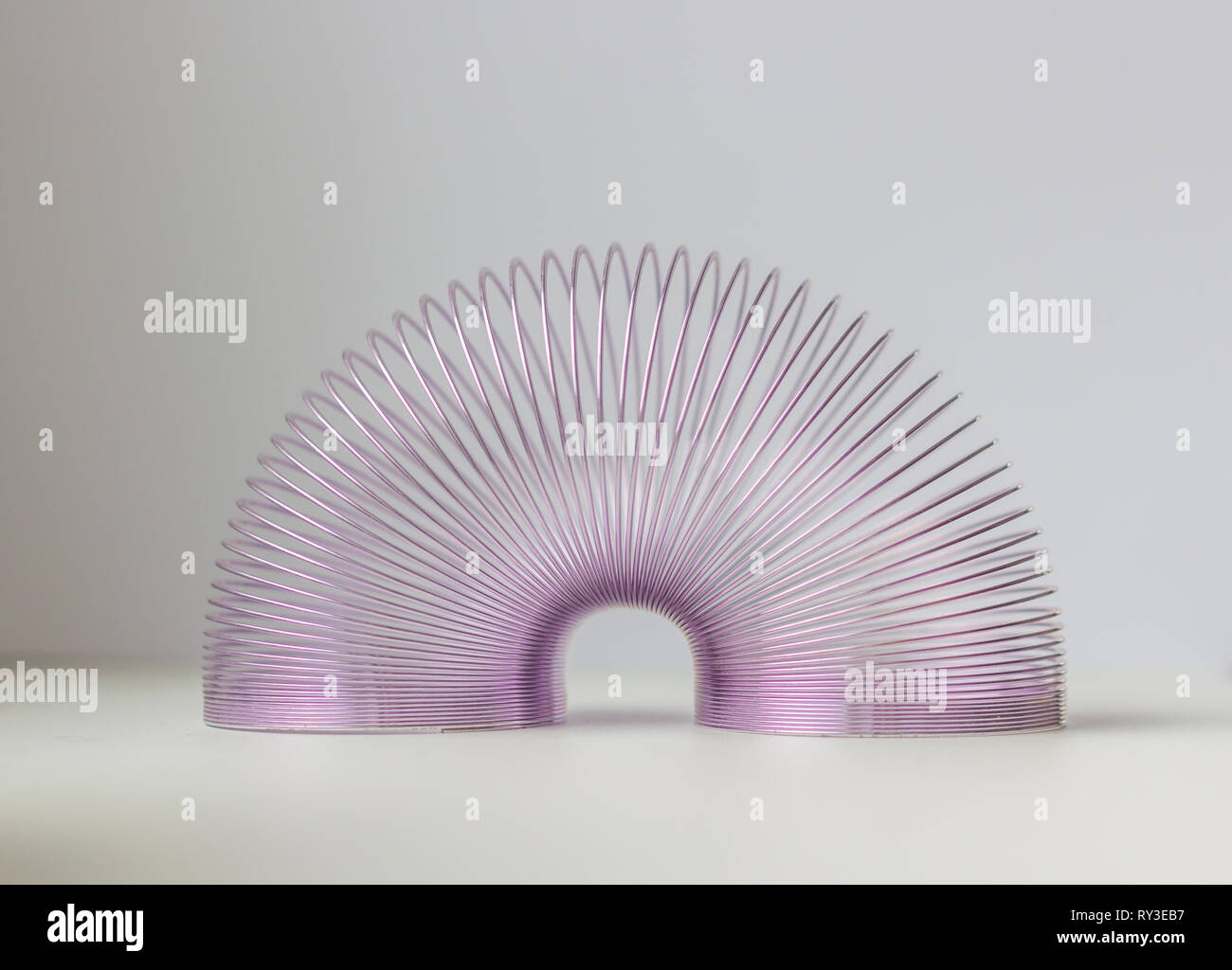 Plastic pink rainbow toy spiral for play, on light background Stock ...