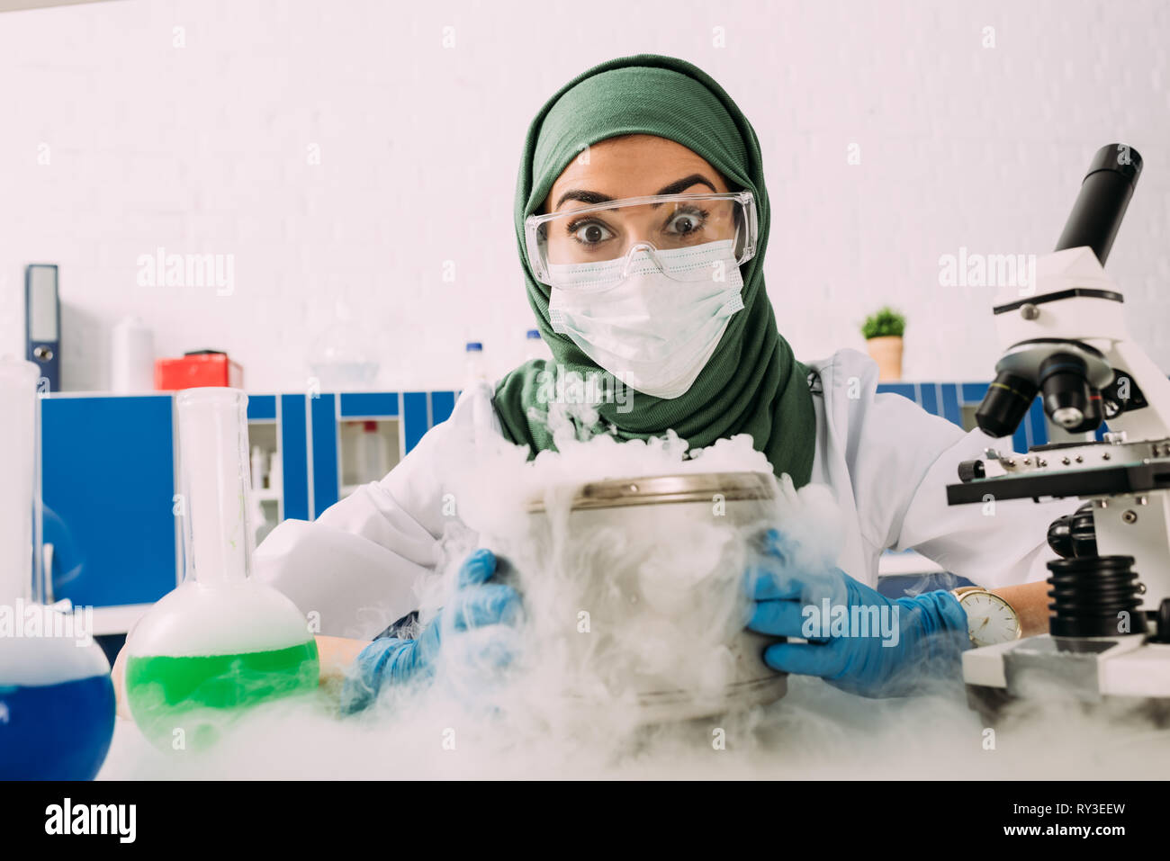 shocked female muslim scientist holding pot with dry ice during ...
