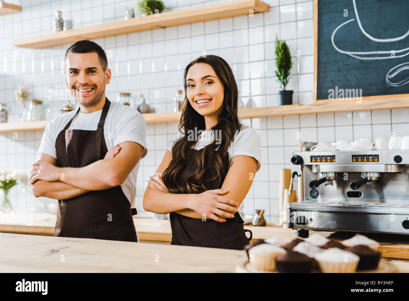 cashiers standing behind bar counter and smiling in coffee house Stock ...