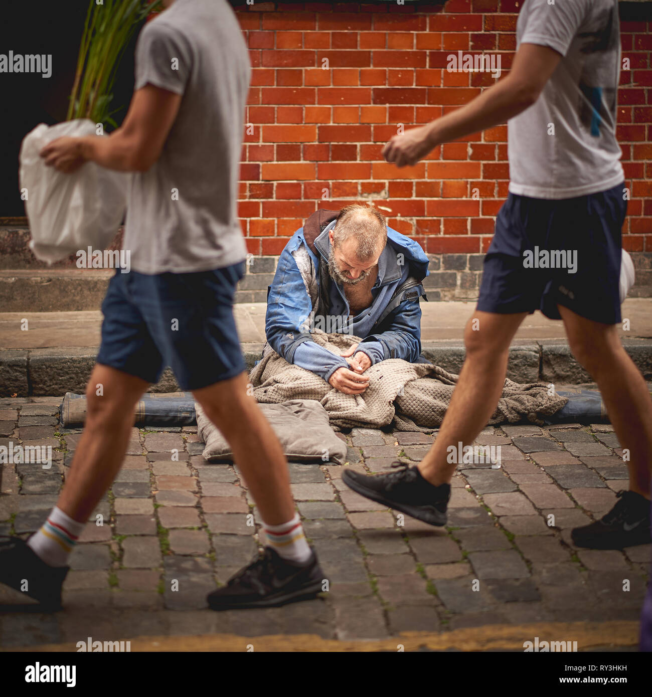 London, UK - June, 2018. A homeless man begging for help in a crowded ...