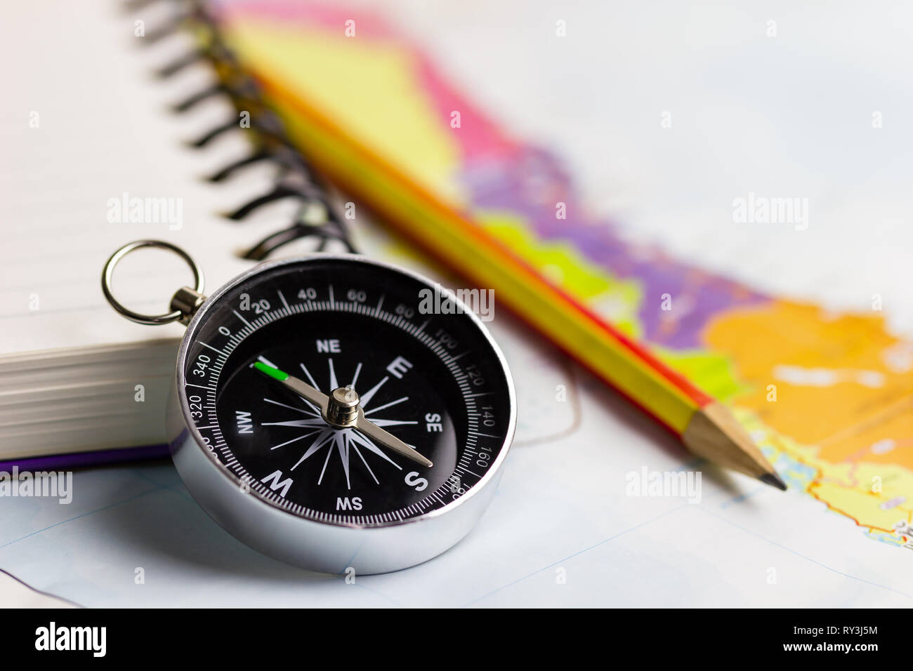 Compass notebook and pencil laid on a paper map. The concept record of ...