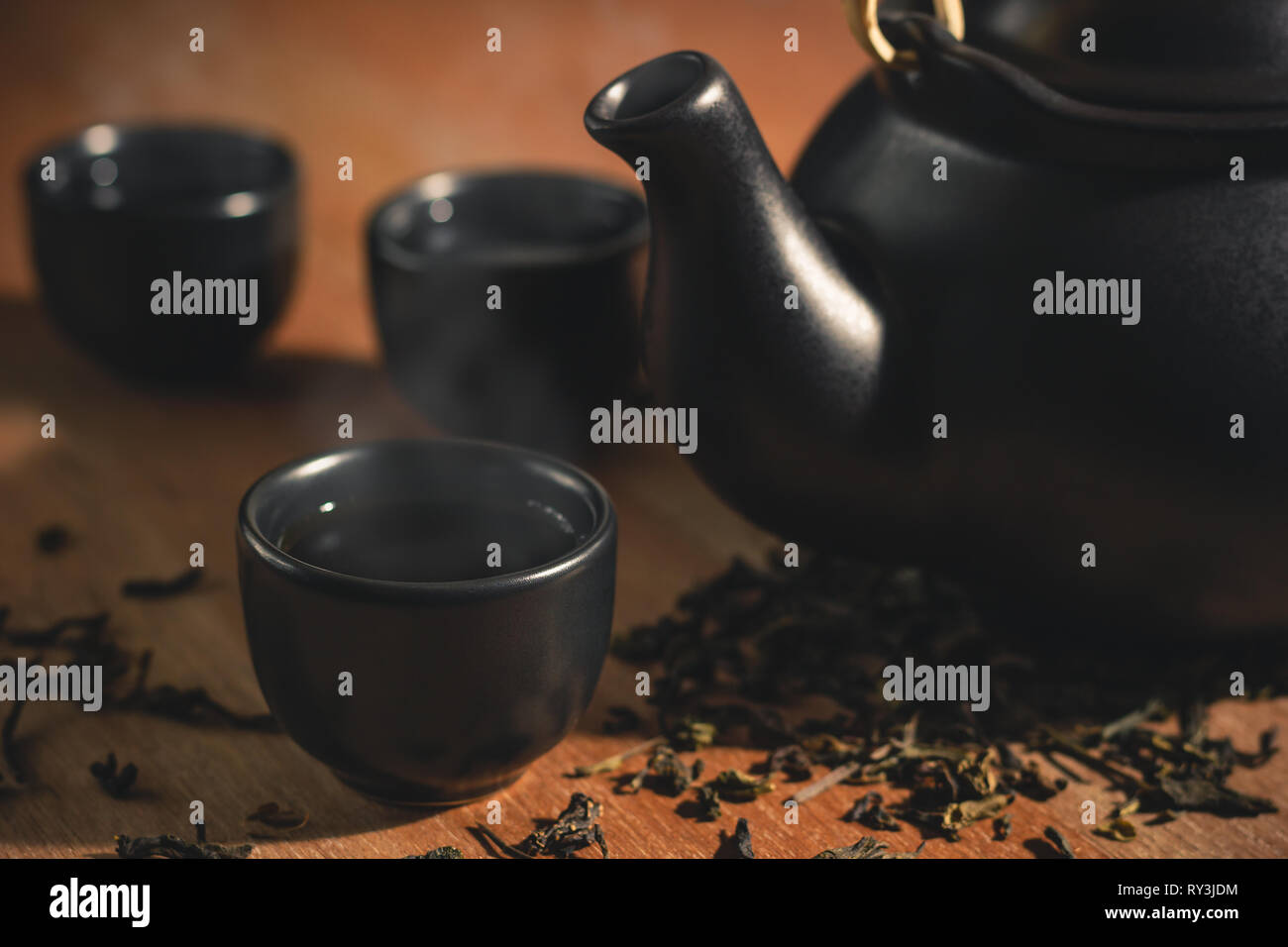 Glass of tea with hot smoke is placed beside a ceramic teapot and dried ...