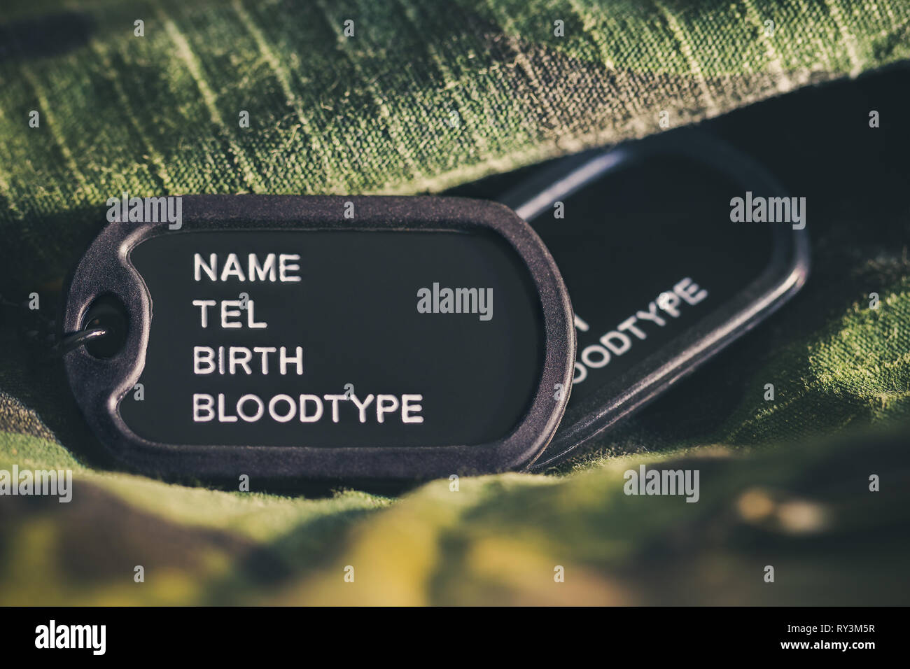 Soldier tag or dog tag laid on military jacket and morning sunlight ...