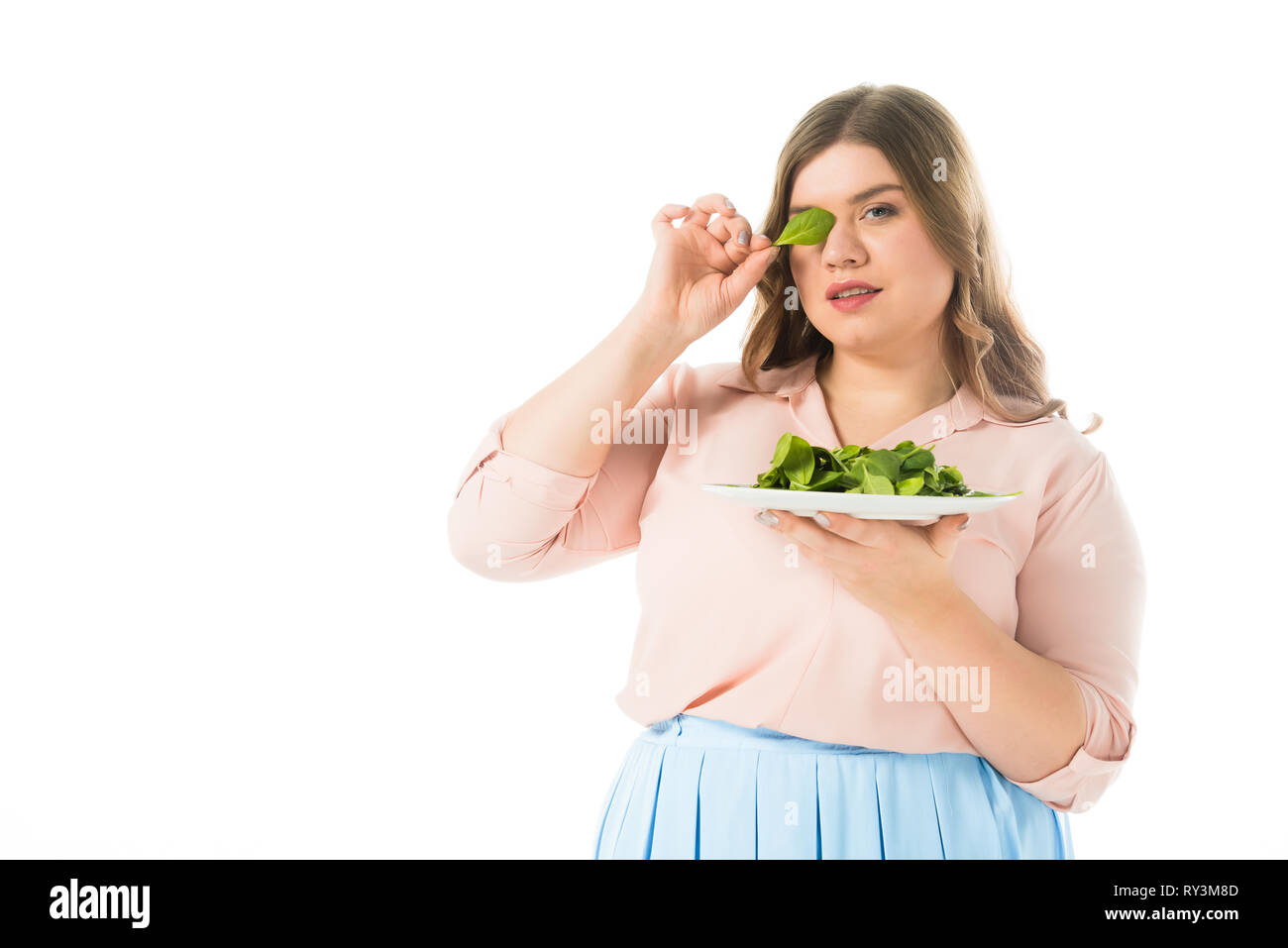 beautiful overweight woman holding fresh green spinach leaf near eye ...