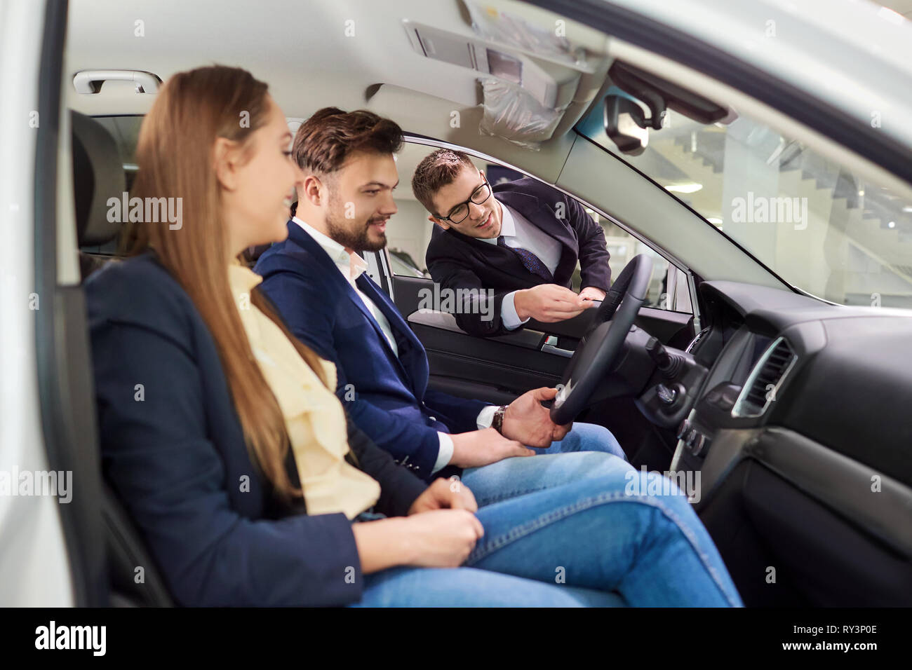 A young couple buys a car in the auto salon Stock Photo - Alamy