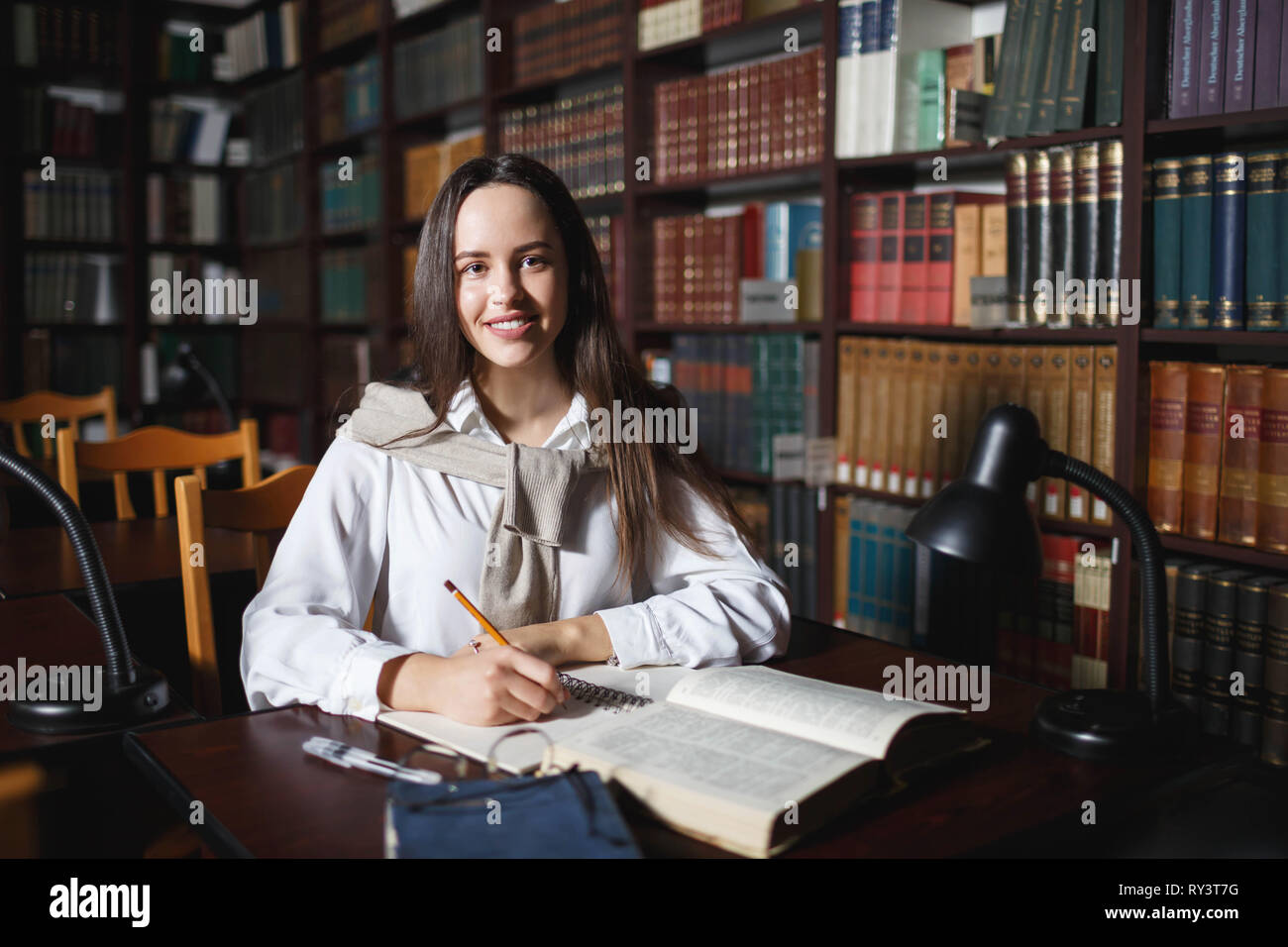 Picture of a female student sitting at the writing desk studying in the ...