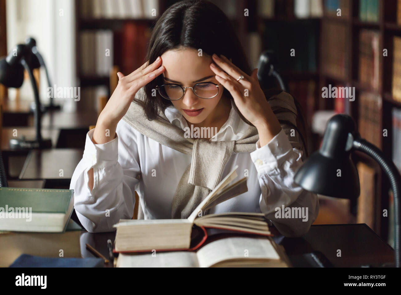 Tired student girl reading many books before the exams Stock Photo - Alamy