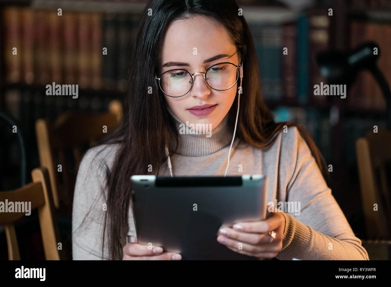University student watching presentation at the tablet and listening in ...
