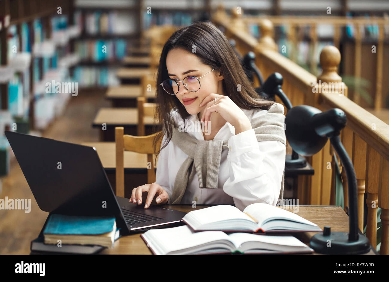 Brunette woman using laptop computer for startup project, researching ...