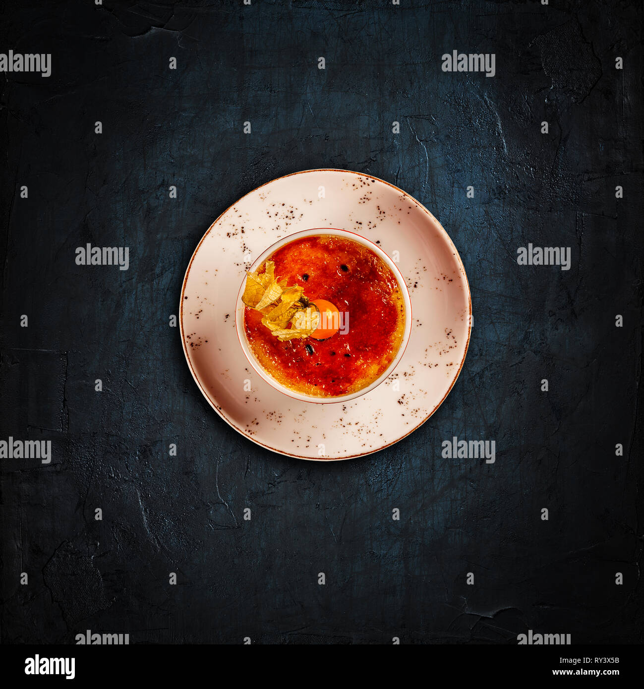 Delicious creme brulee decorated with cape gooseberry, flat lay Stock ...