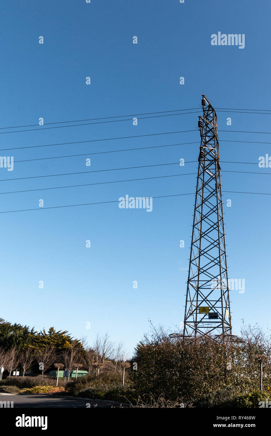 Electricity pylon in an urban environment, with blue sky behind Stock ...