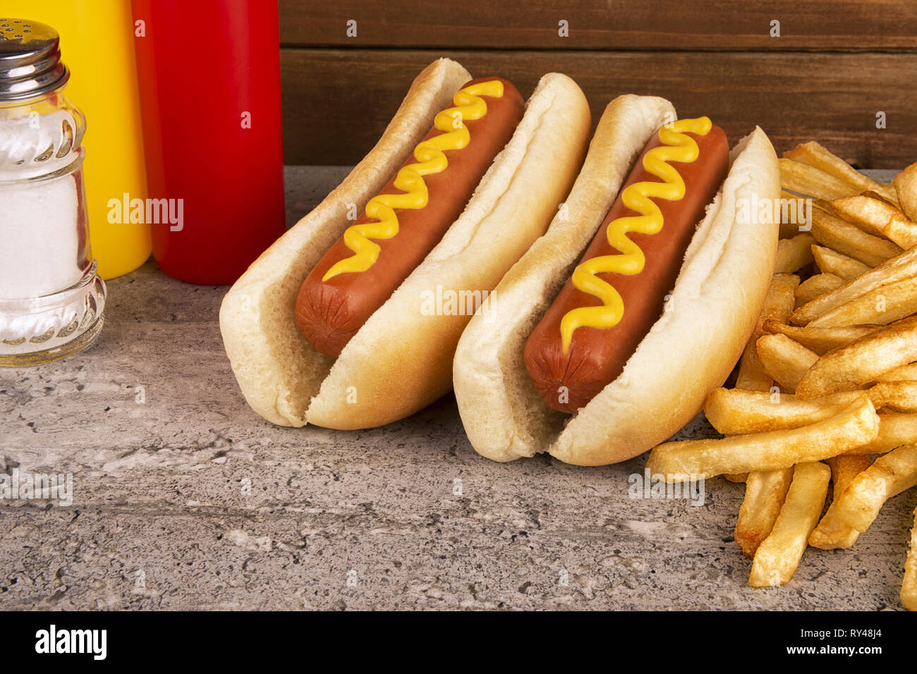 Duo of hot dogs and french fries on table. Fast food restaurant concept ...