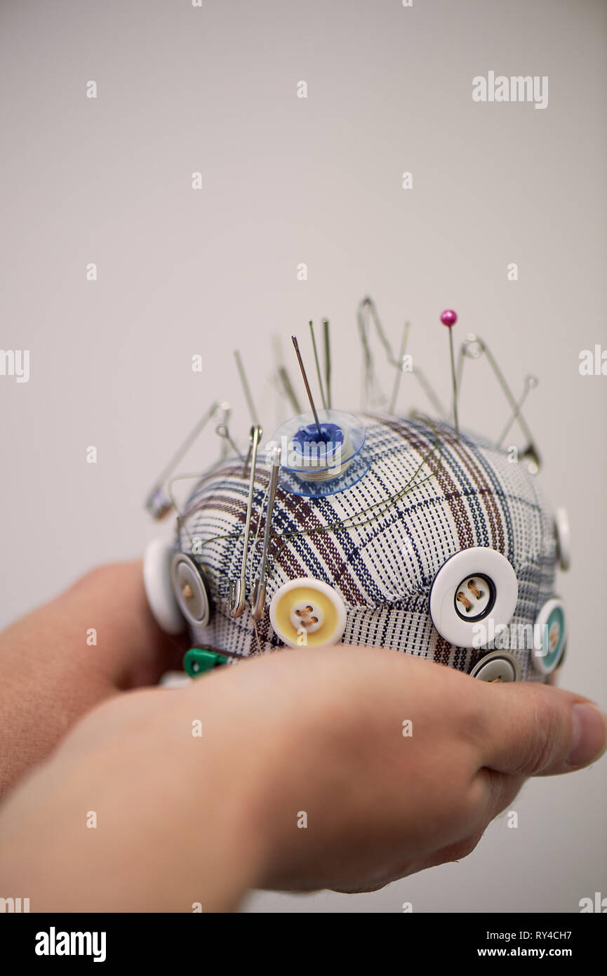Plaid pin cushion in the hands of seamstresses.Handmade, sewing Stock ...