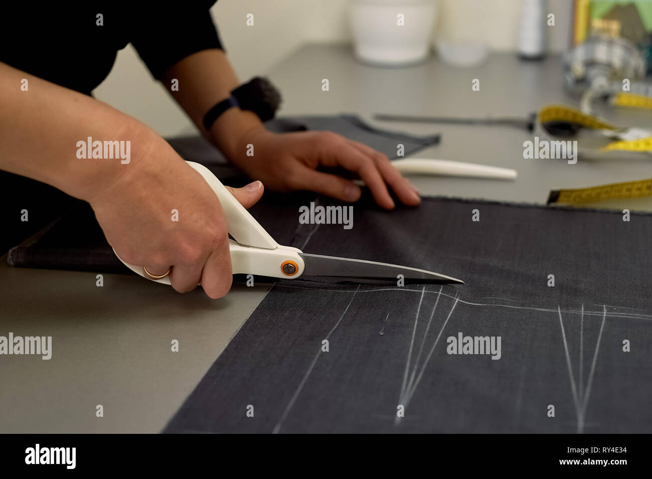 Master cuts fabric. Nesting. Suiting fabric marked with white chalk ...