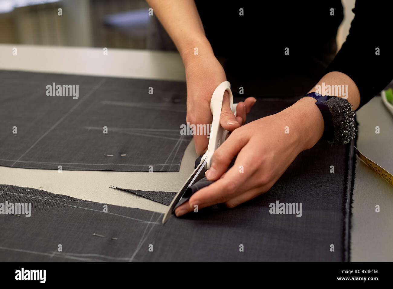 Master cuts fabric. Nesting. Suiting fabric marked with white chalk ...